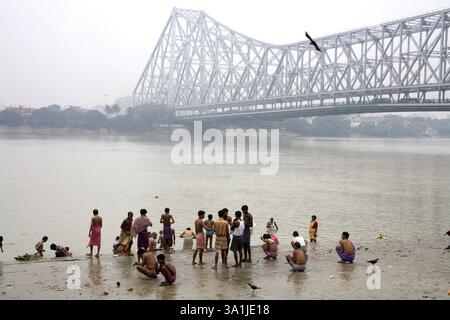 Activities on Babu ghat, Howrah bridge over Hooghly river in background ...