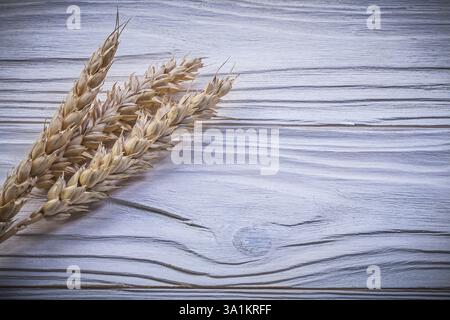 Stack of ripe wheat rye ears on wooden board food and drink concept ...