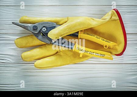 Leather protective gloves tin snips on wooden board construction ...
