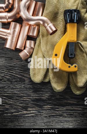 Plumbing brassware pipe cutter safety gloves on wooden board Stock ...