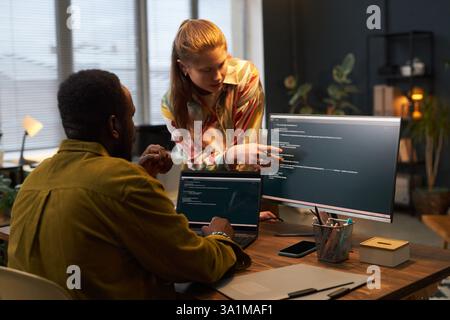 African American programmer typing codes on keyboard sitting at his ...