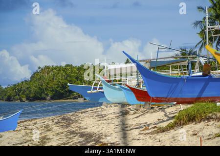 Traditional bangka boat moored on beach, Miniloc Island, Palawan ...