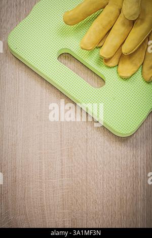 Protective gloves kneeling pad on wooden board gardening concept Stock ...
