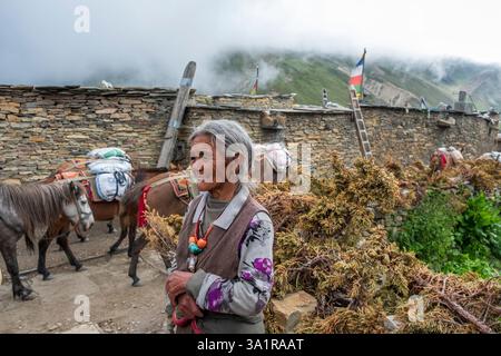 An elderly woman poses in Nar village, one of the restricted areas in ...