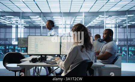 System admin working in diverse computer network security data center ...