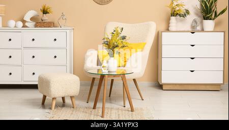 Interior of living room with armchair and mimosa flowers in vases Stock ...