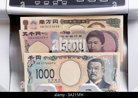 Japanese money - yen in a counting machine Stock Photo - Alamy