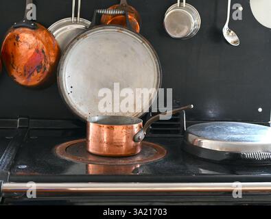 Aga stove with copper and steel cooking pots in kitchen interior Stock ...