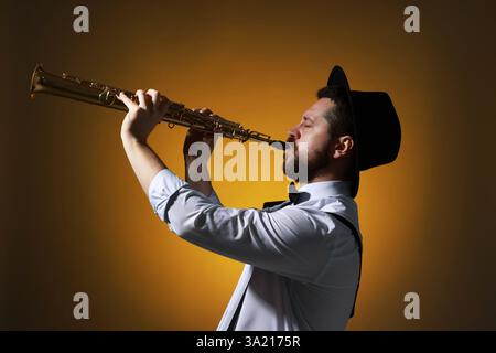 Professional musician playing soprano saxophone on blue background with ...