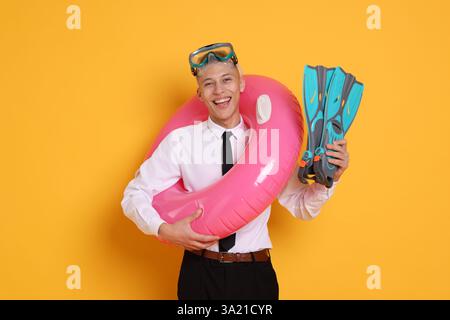 Businessman with inflatable ring, flippers and diving mask on light ...