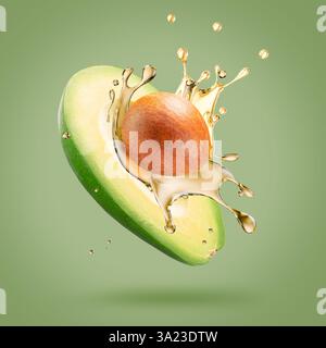 avocado with oil splash on a light green background Stock Photo - Alamy