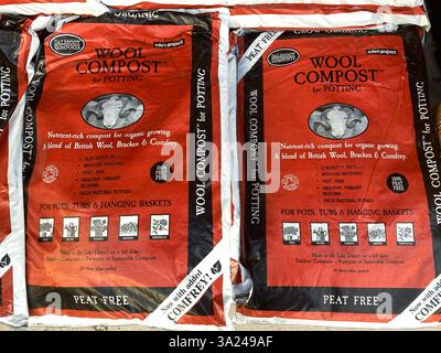 A stack of bags of peat free wool and bracken compost for sale in a ...