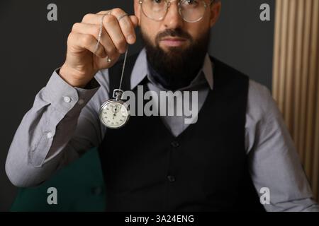 Hypnosis session. Man swinging vintage pocket watch indoors Stock Photo ...