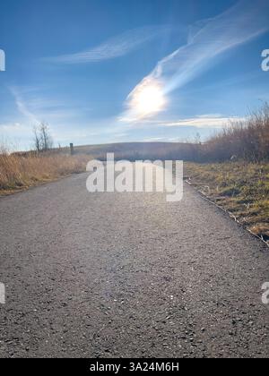 Bright sun shining over a winding mountain road surrounded by clouds ...