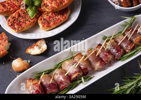 dates wrapped in bacon and delicious tapas Stock Photo - Alamy