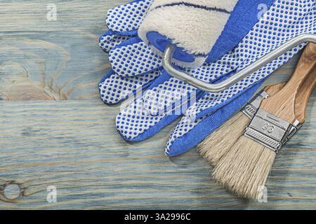 Paint roller brushes protective gloves on wood board construction ...