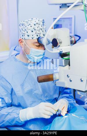 Man under a surgical microscope for vision correction. Eye surgery. A ...
