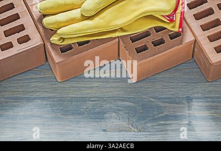 Set of building bricks protective gloves on wooden board construction ...