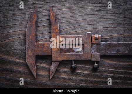 Rusted old-fashioned measuring slide caliper on vintage wooden board ...