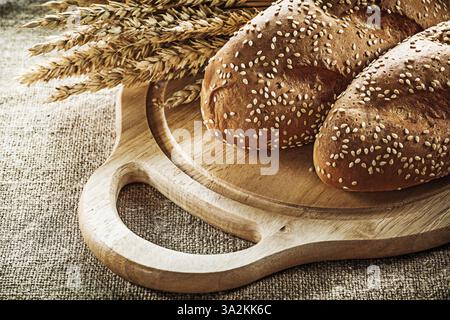 Carving board bread wheat ears on sacking background Stock Photo - Alamy