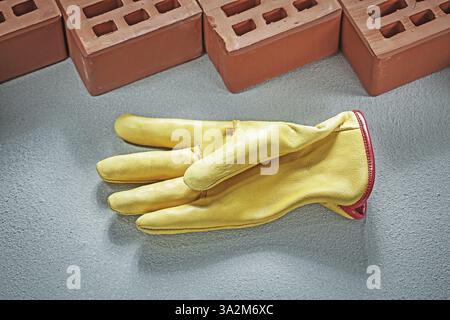 Red construction bricks safety gloves claw hammer on concrete ...