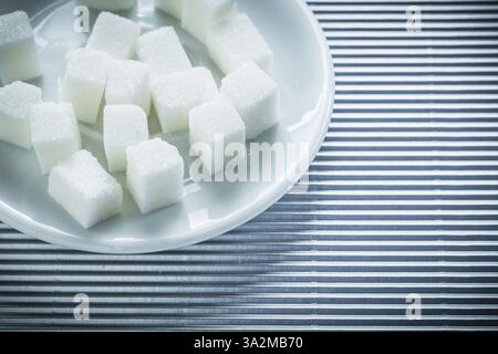 Saucer with sugar cubes on striped background Stock Photo - Alamy