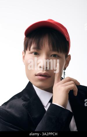 Young man with tattoo wearing red t-shirt standing over isolated white ...