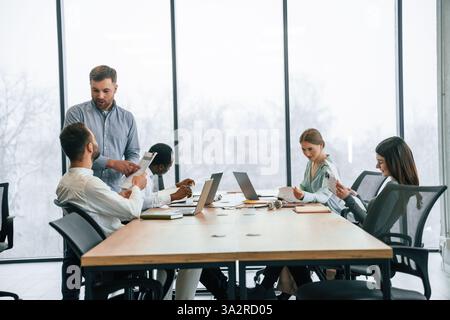 Bunch of laptops on the table. Team of office workers are together ...