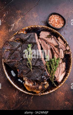 Roast Venison leg, baked meat of roe deer with bone on a tray with ...