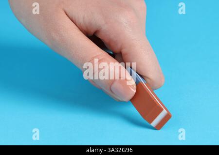 Woman using eraser on light blue background, closeup Stock Photo - Alamy