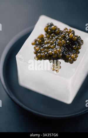 A luxurious serving of beluga caviar presented on a clear ice block ...