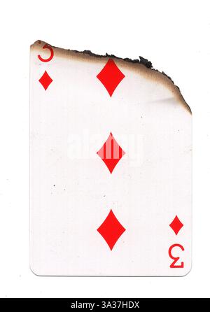 Partly burnt playing card in the suit of diamonds isolated on a white ...