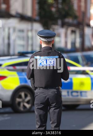 Police officer pictured from behind at a crime scene in the UK Stock ...