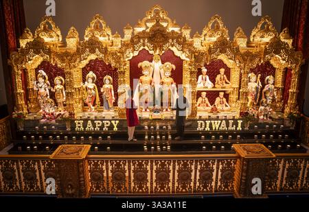 Left to right Arjun Patel and Jay Patel light candles during ...