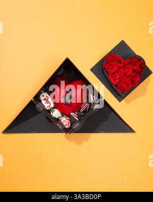 Gift box and chocolate heart sweets over laptop on office desk table ...