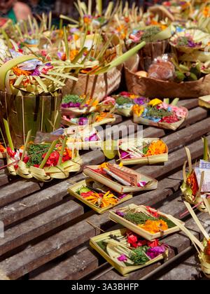 An altar table with traditional Balinese offerings and smoking incense ...