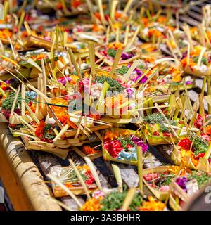 An altar table with traditional Balinese offerings and smoking incense ...