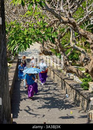 Visitors wearing sarongs walk in the garden at Uluwatu Temple (Pura ...