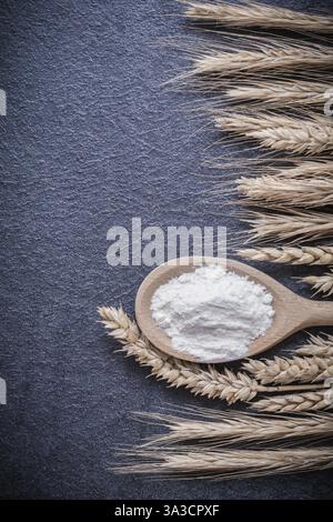 Wooden spoon with flour golden wheat ears on black background Stock ...