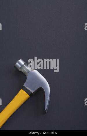 vertical version claw hammer with yellow handle on black background ...