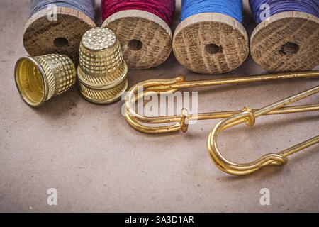 Wooden spools of threads thimbles clasp pins on vintage background ...