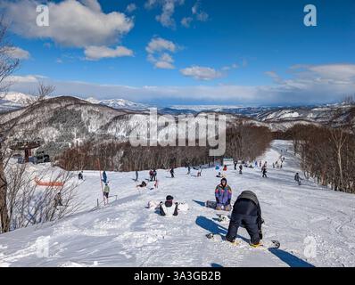Crowds of skiers and snowboarders on a busy ski slope in Madarao Kogen ...