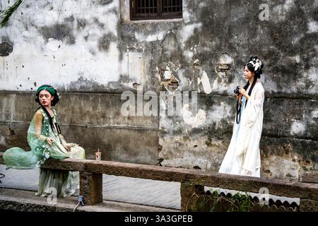 Two girls in traditional hanfu clothing pose for pictures on Pingjiang ...