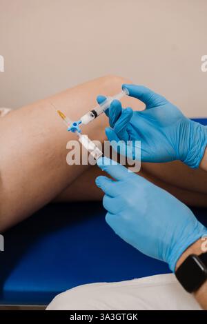 Vascular surgeon injects chemical solution into woman leg for ...