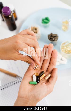 Nutritionist is holding different dietary supplement pills in her hands ...