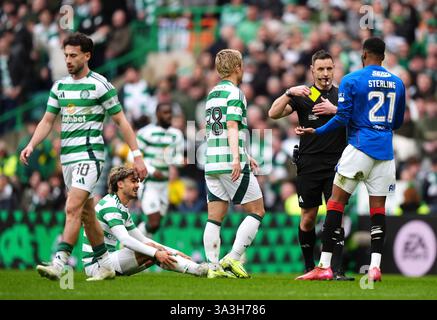 Referee Steven McLean shows a yellow card to Rangers' Thelo Aasgaard ...