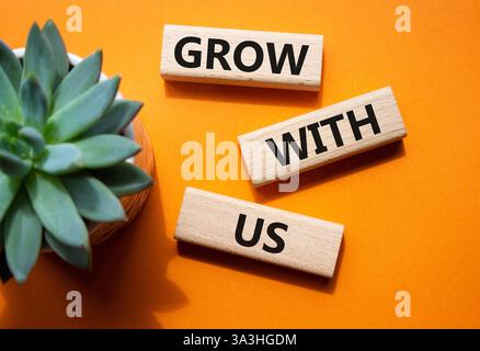 Grow with us symbol. Concept words Grow with us on wooden blocks on a ...