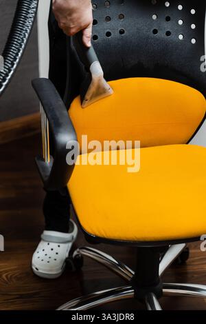 Housekeeper is extracting dirt from upholstered sofa using dry cleaning ...