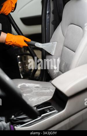 Car cleaner is extracting dirt from car seat using dry cleaning ...