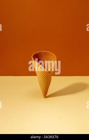 An empty ice cream cone on a blue background Stock Photo - Alamy